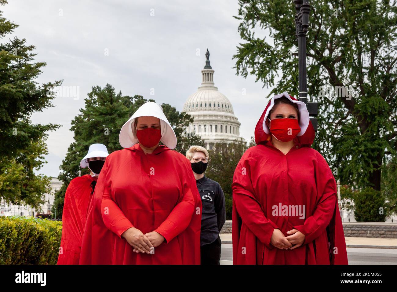 Protesters dressed as handmaids and a guardian from The Handmaid's Tale ...