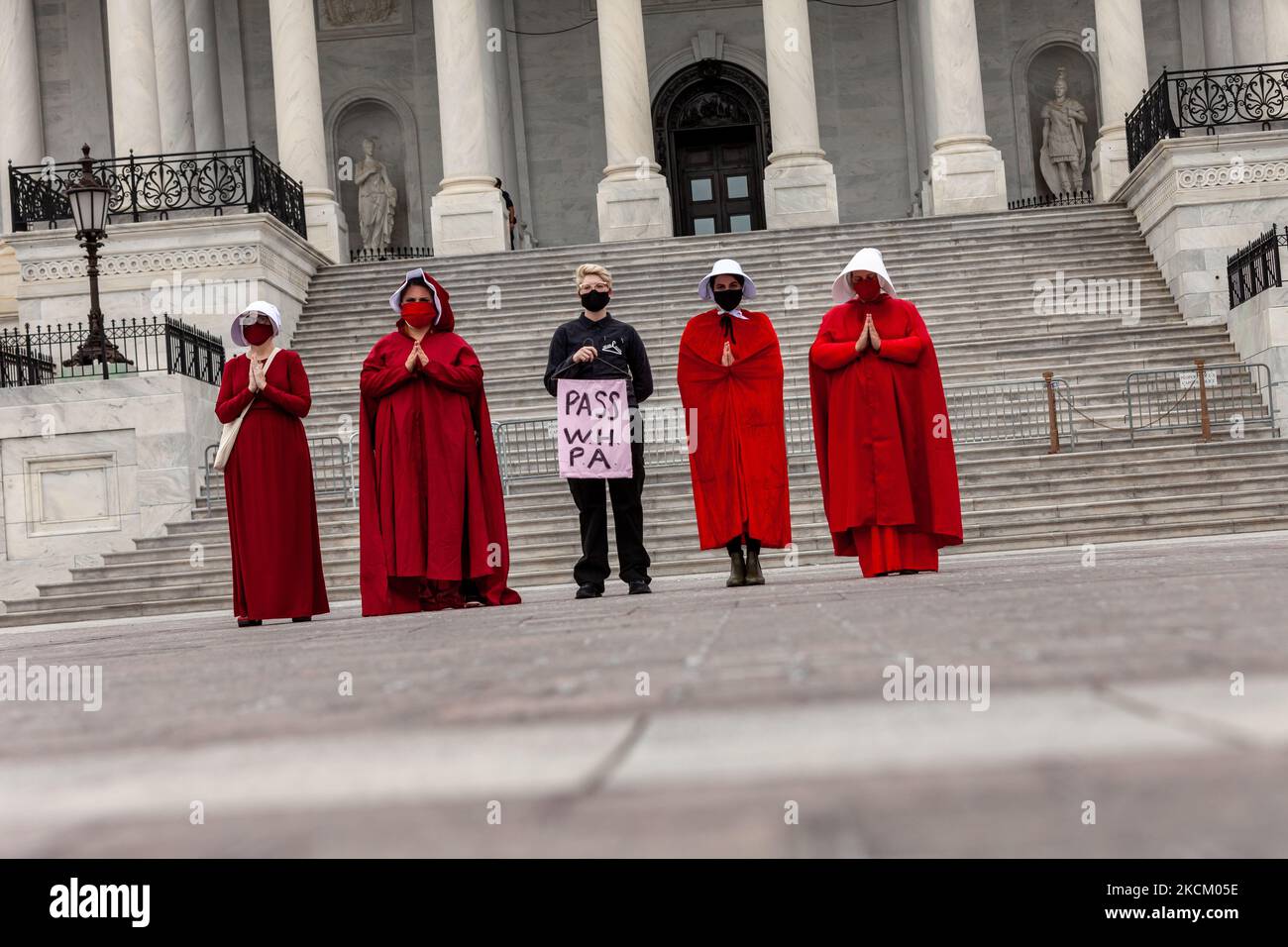 Protesters dressed as handmaids and a guardian from The Handmaid's Tale ...