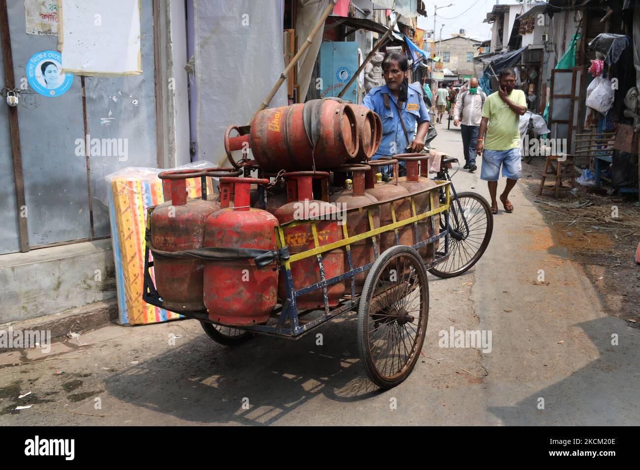 A Liquefied petroleum gas (LPG) distribution worker rides a cart loaded ...