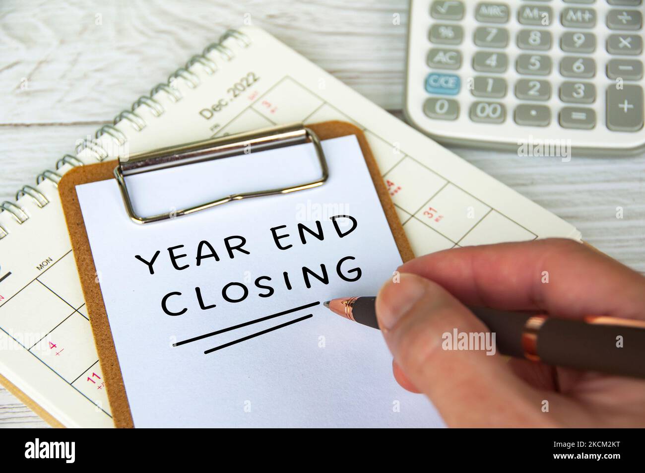Year end closing written on notepad with December calendar and ...