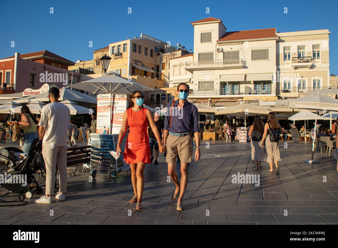 Locals and tourists are seen with facemask walking at the waterfront ...