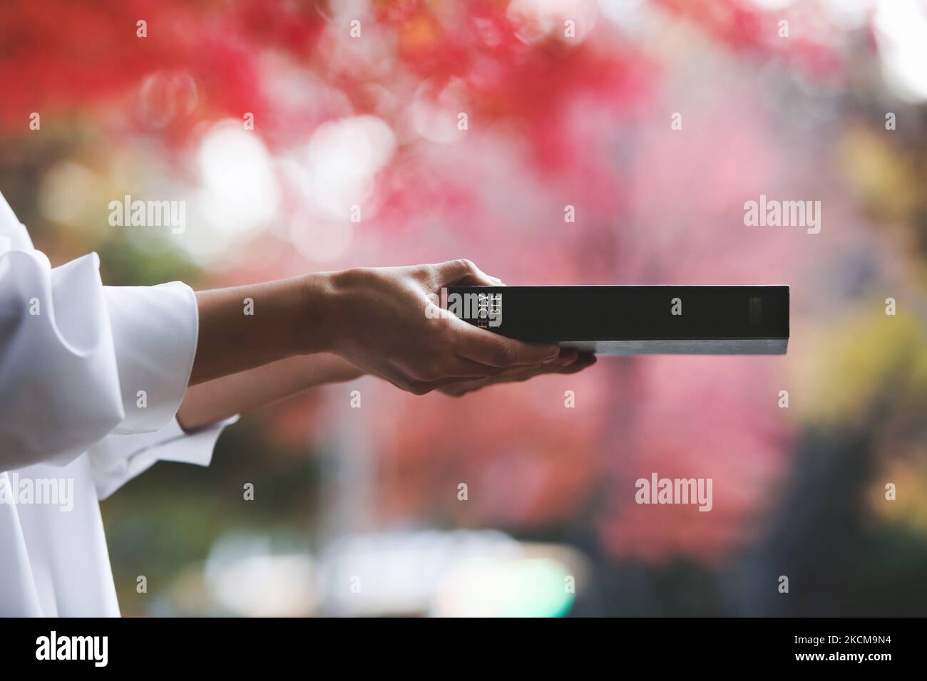 A Christian preaching while delivering the holy bible with red leaves ...