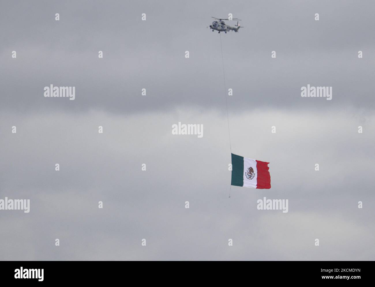 A Mexican army helicopter transports a Monumental Flag of Mexico in ...