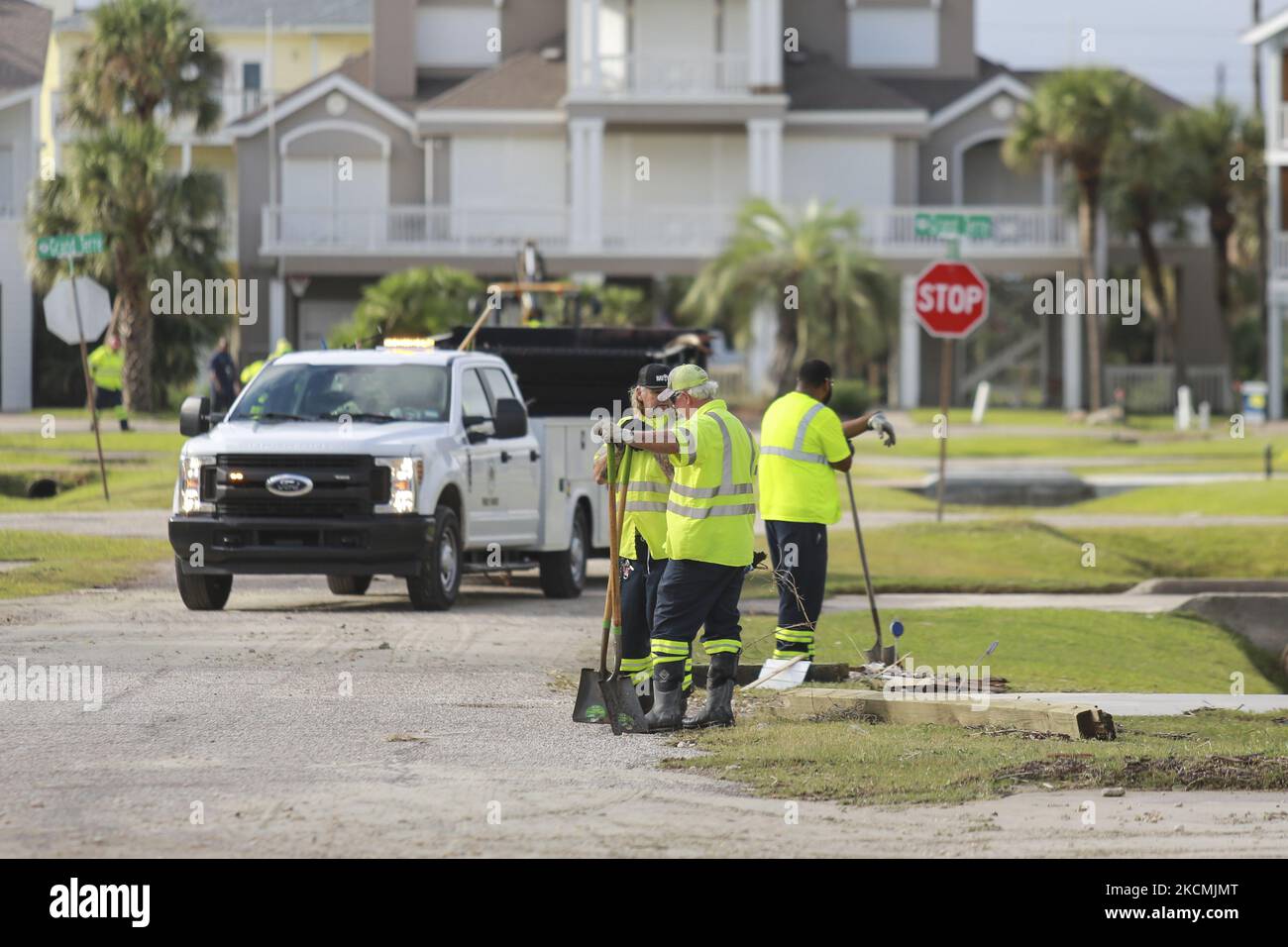 Cleanup crews move through the neighborhood of Pirate’s Beach on ...