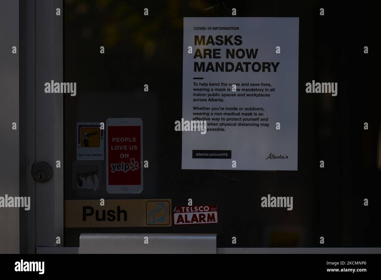 Sign 'Masks Are Now Mandatory' seen on a entrance door to a shop in Edmonton. Alberta has ...