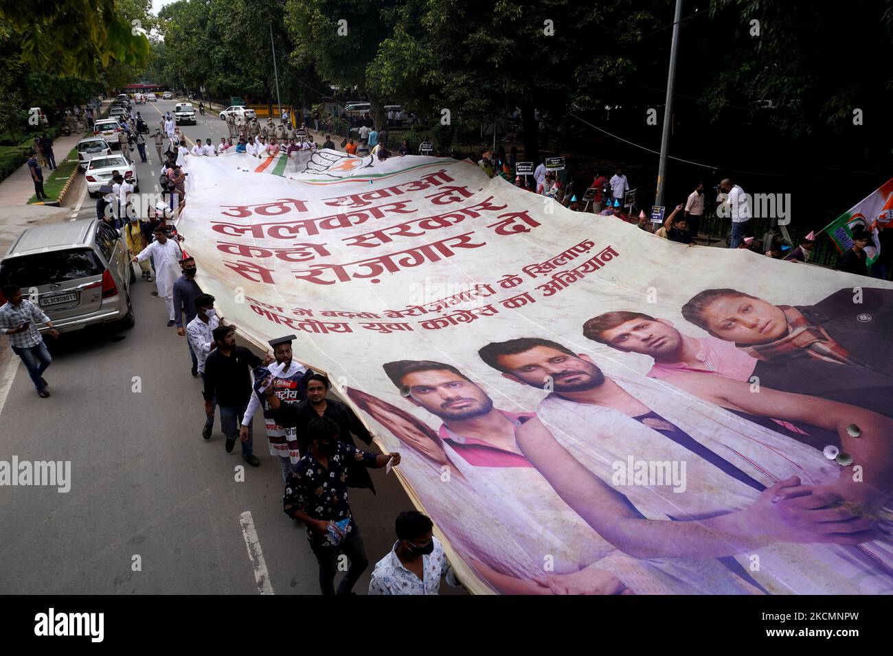 Activists of the Indian Youth Congress (IYC) party carry a giant banner ...