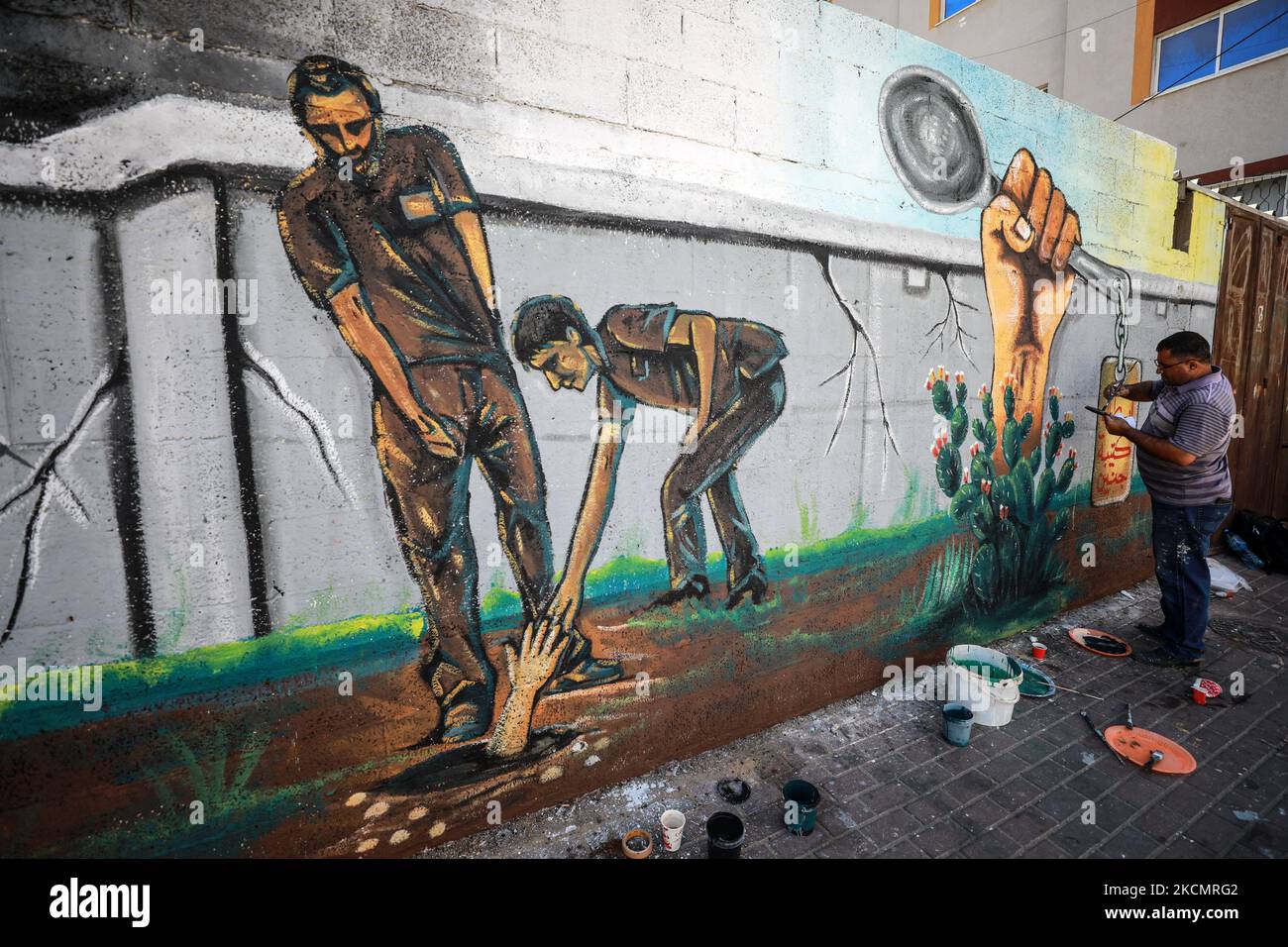 A Palestinian artist paints a mural painting glorifying six Palestinian ...
