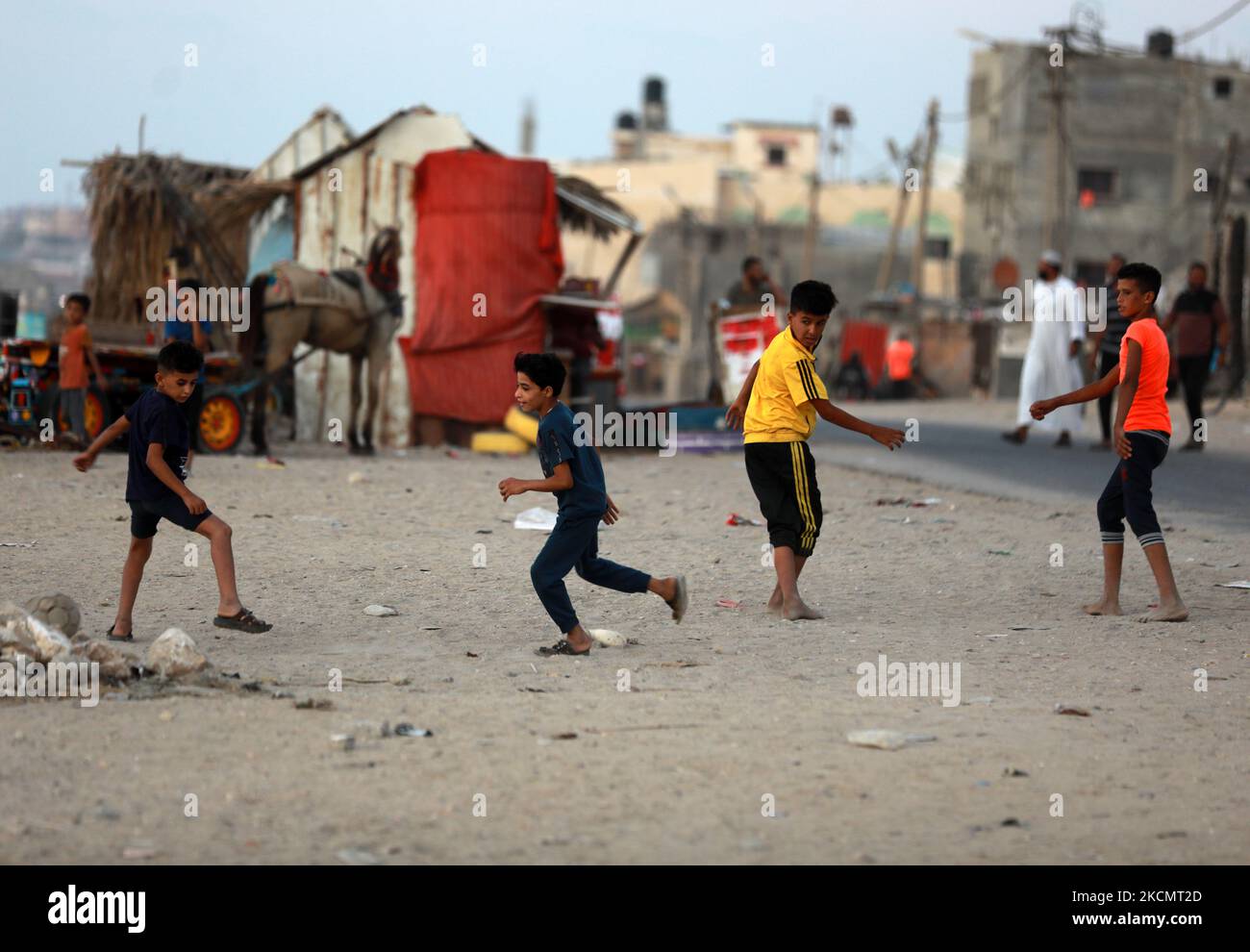 Palestinian boys play with a football outside their homes in Gaza City ...