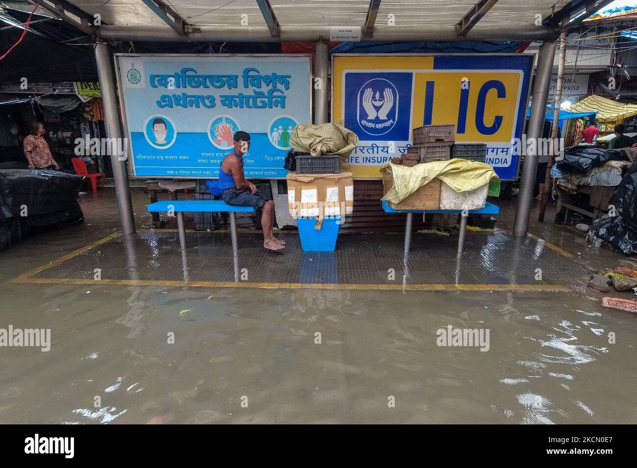A man is seen siting on a high ground of a bus stop to escape flood ...