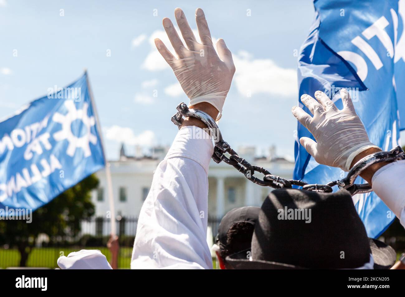 An actor with chains on his wrists raises his hands as the crowd dances ...