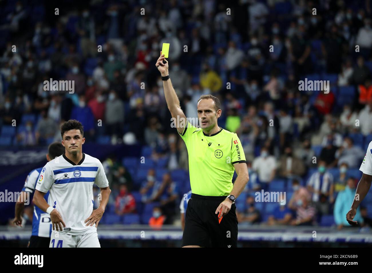 The referee Mario Melero Lopez shows a yellow card during the match ...