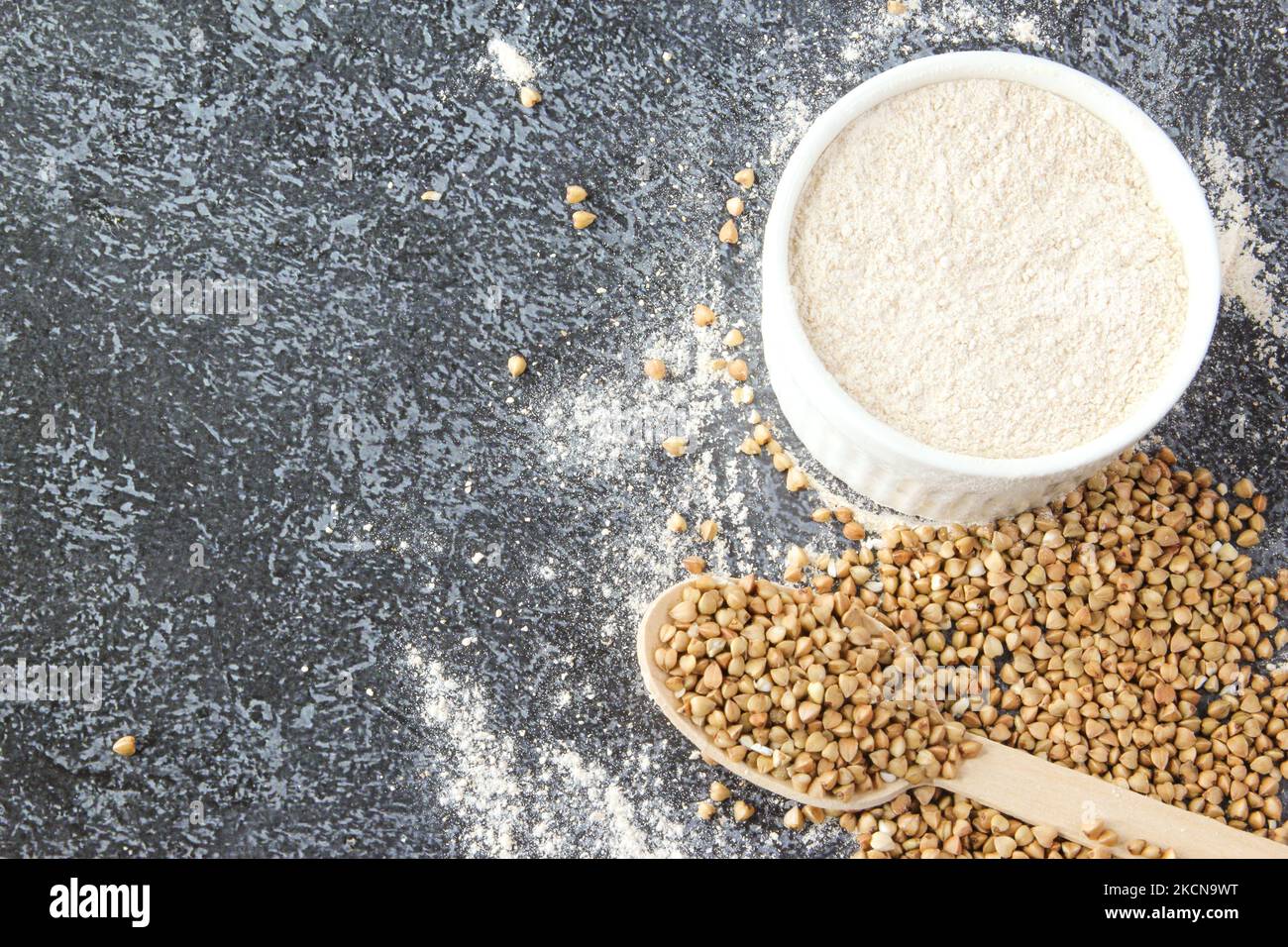 Buckwheat flour in a white bowl and wooden spoon, raw green buckwheat ...