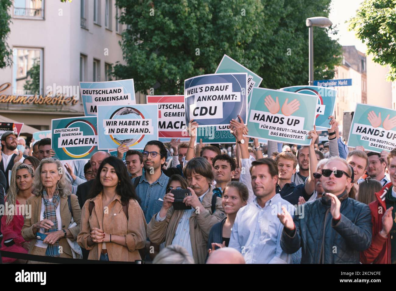 Supporters hold election placards " German work together" during the ...