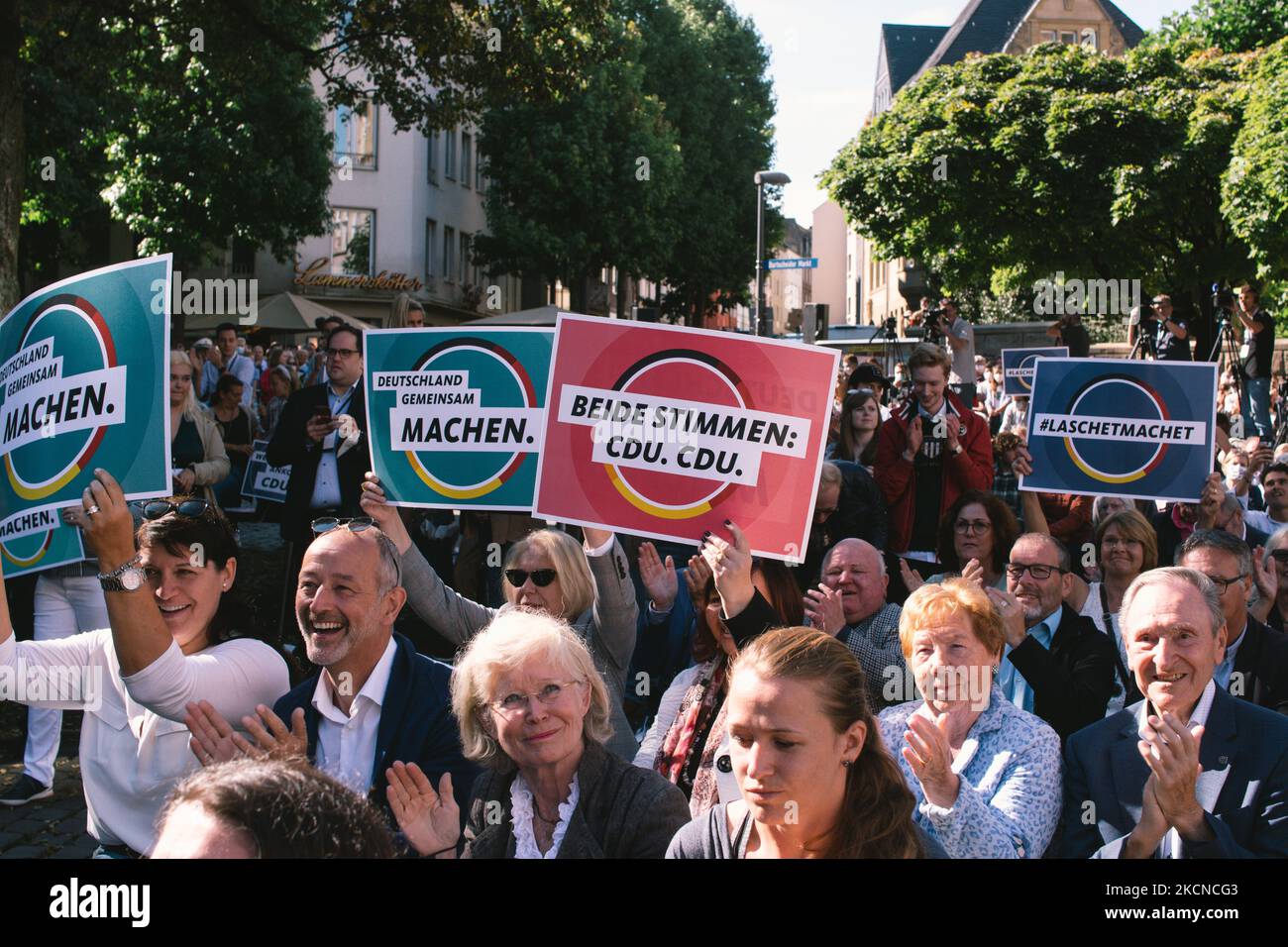 Supporters hold election placards " German work together" during the ...