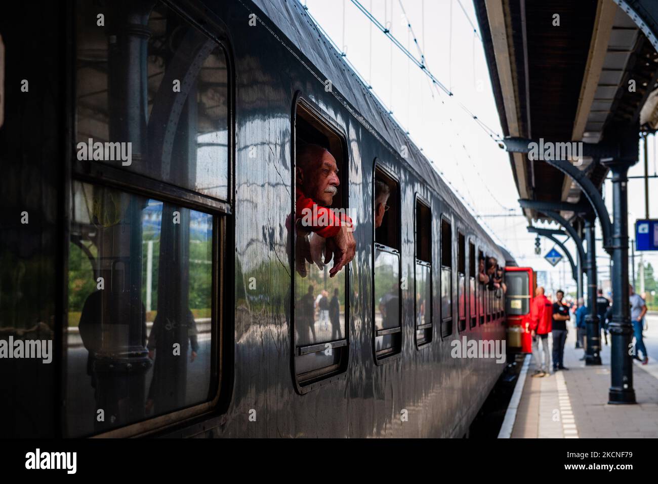 A passenger is looking out of the window of the 40's German locomotion ...