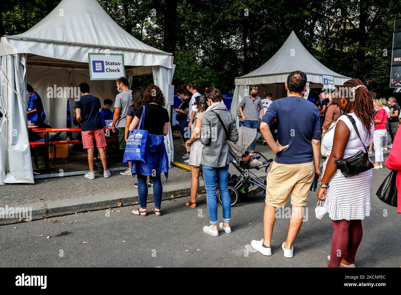 Members of public wait in line to check their Covid status before ...