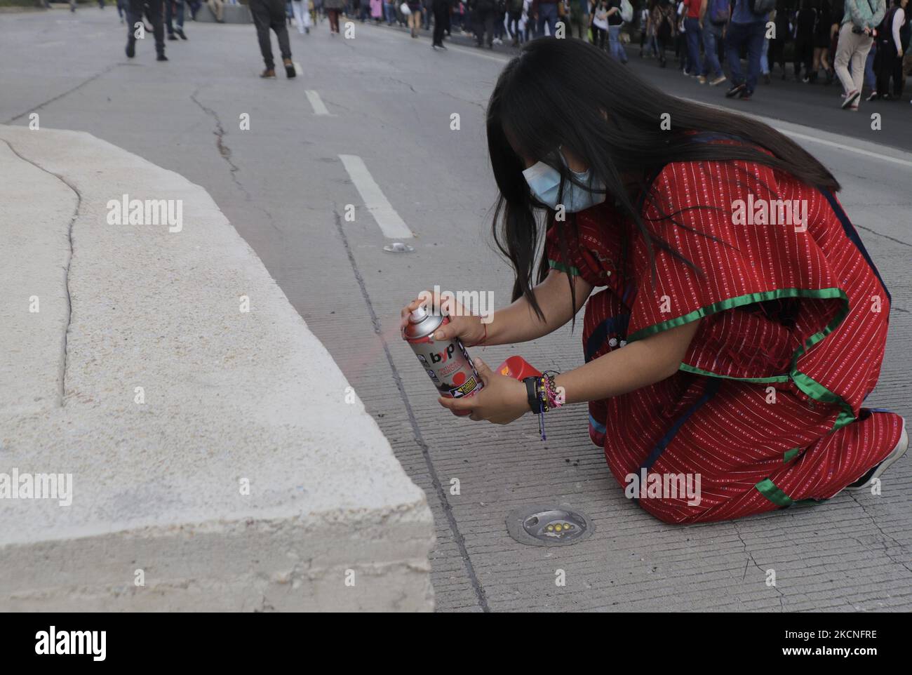 A woman from the indigenous Triqui community makes some graffiti in the ...