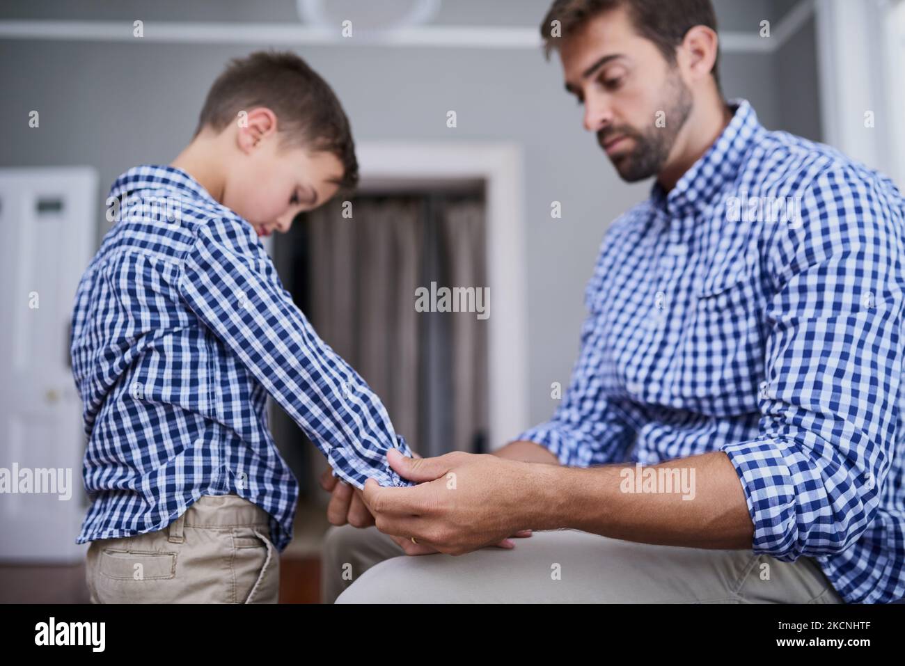 Dressing up just like dad. a handsome young man and his son getting dressed in the morning Stock ...