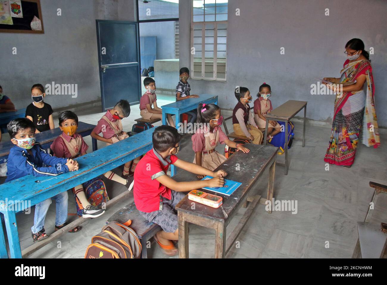 Primary section students wearing protective face mask attend their ...