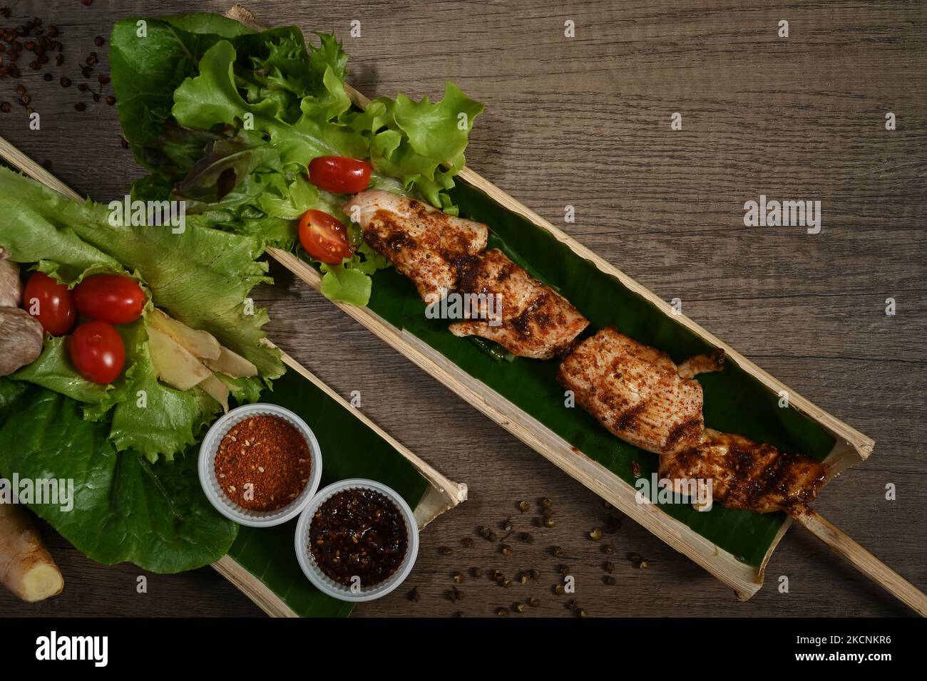 Bamboo barrel plat with grilled meat skewers on wooden table. Mala Chinese BBQ is meat or ...
