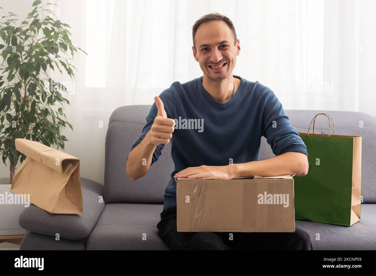 Present from distant friend. Happy millennial man unpack open box with ... Present from distant friend. Happy millennial man unpack open box with ...