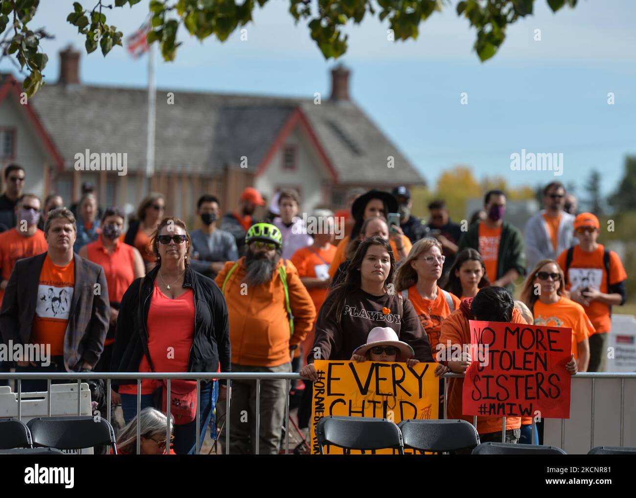 People wearing orange shorts attending an outdoor official ceremony at ...