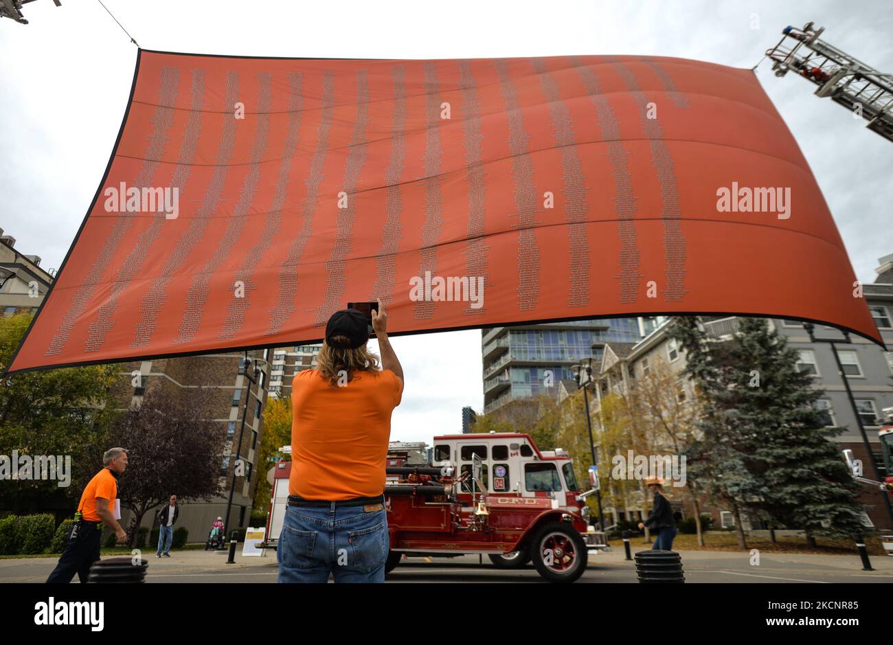 A man takes a photo of a banner with names of childrens from the ...