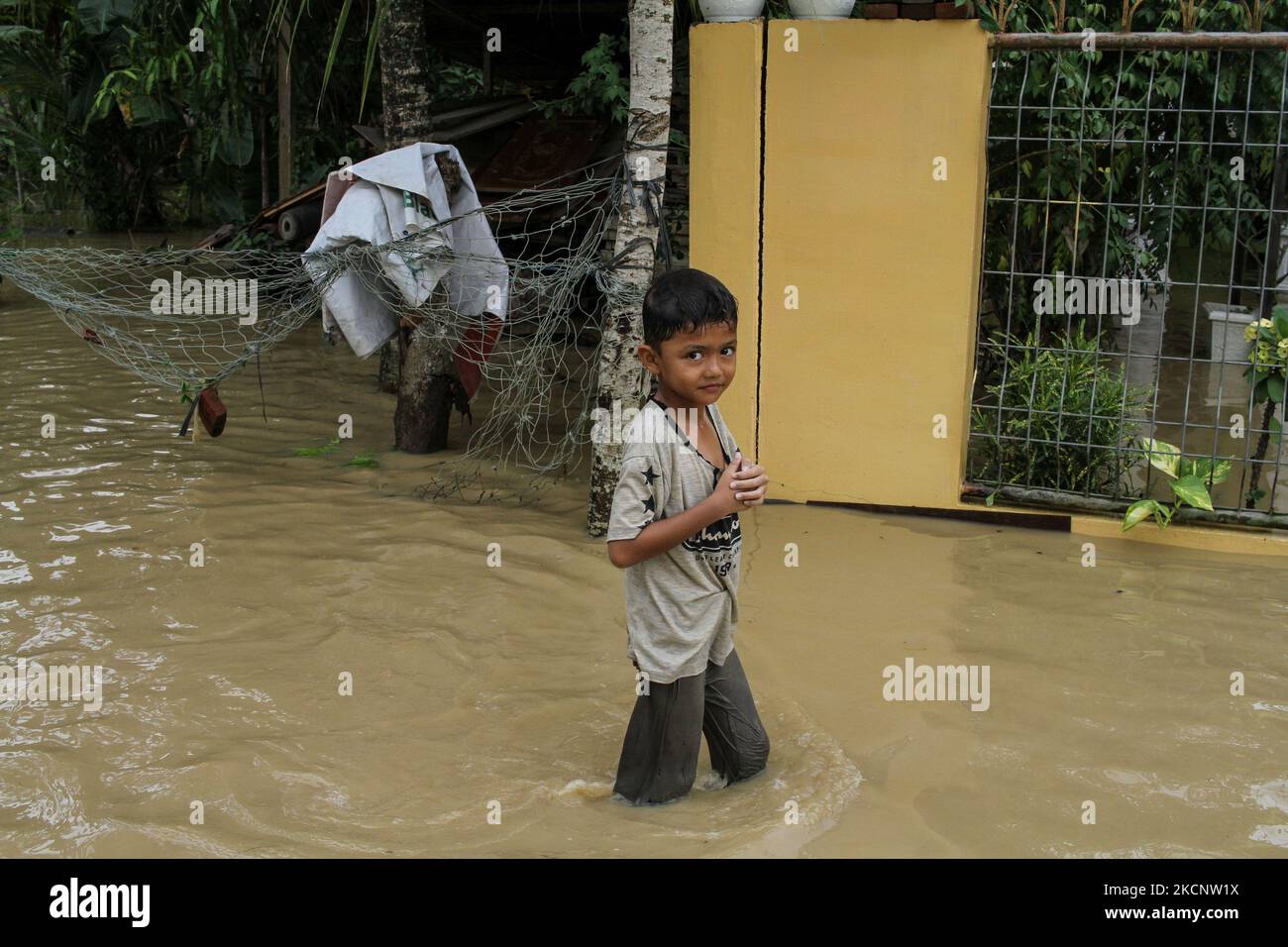 A child is seen walking through a flood caused by a river overflowing ...