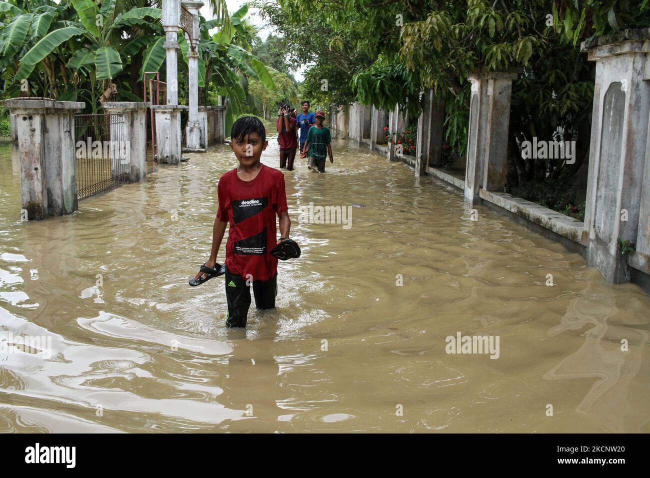 A child is seen walking through a flood caused by a river overflowing ...