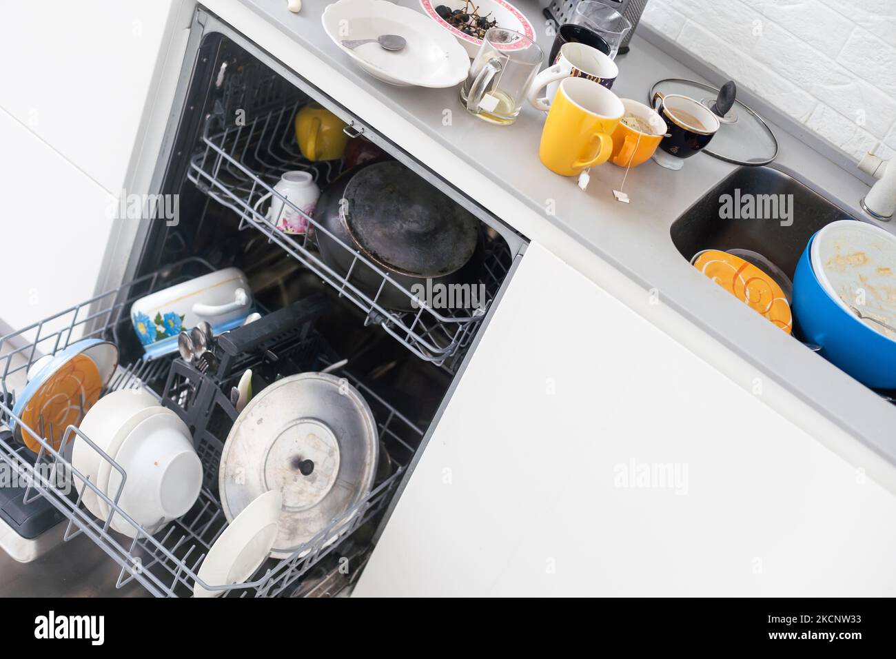 a stack of dirty dishes is on the door of the dishwasher Stock Photo ...