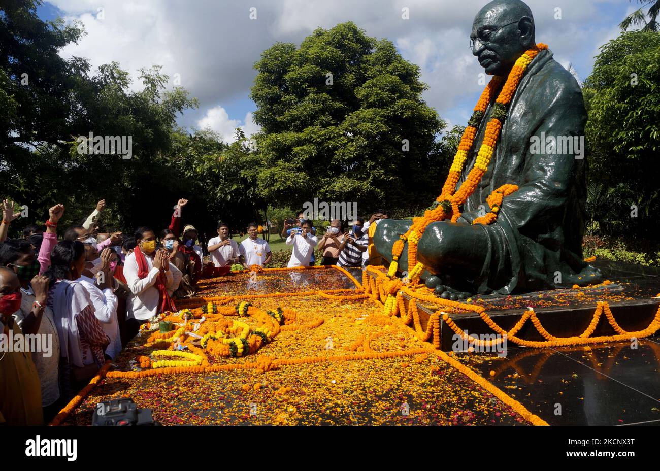 People pay floral tribute to the statue of Mahatma Gandhi at a public ...