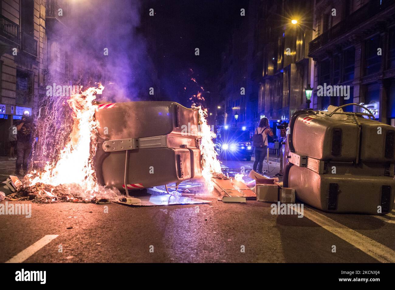Containers are seen on fire in front of the police. The activist group ...