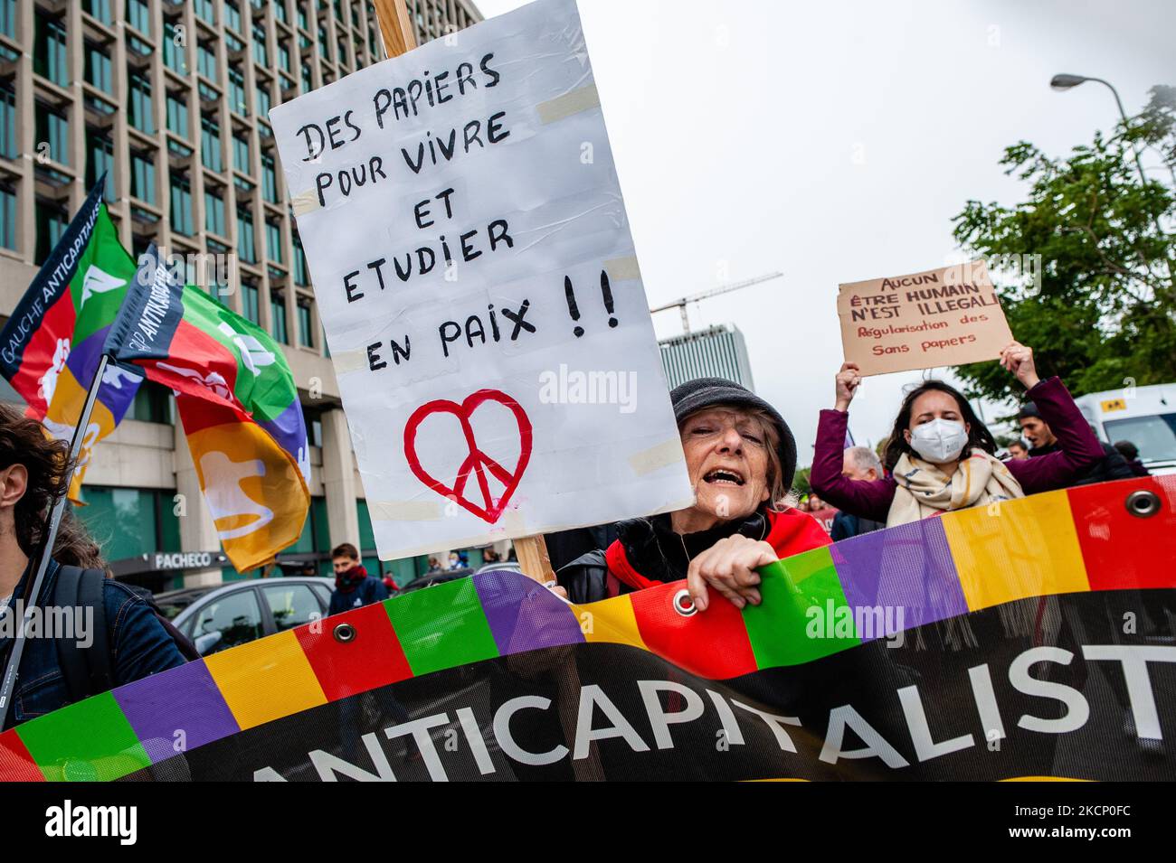 A woman is shouting slogans behind an anti-capitalism banner, during ...