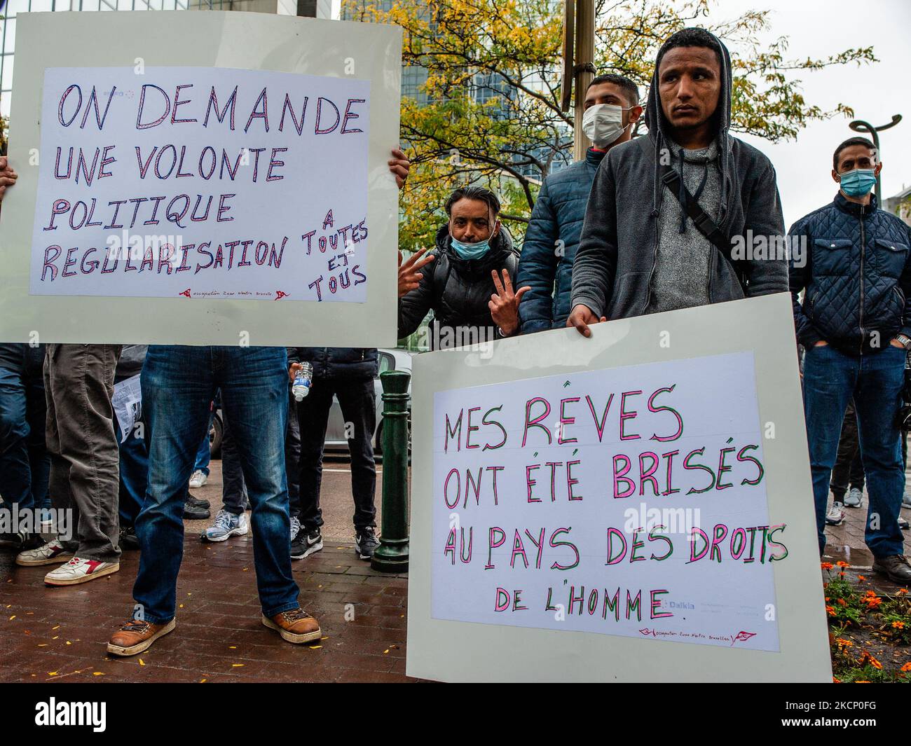 A group of immigrants without papers are holding placards asking for ...