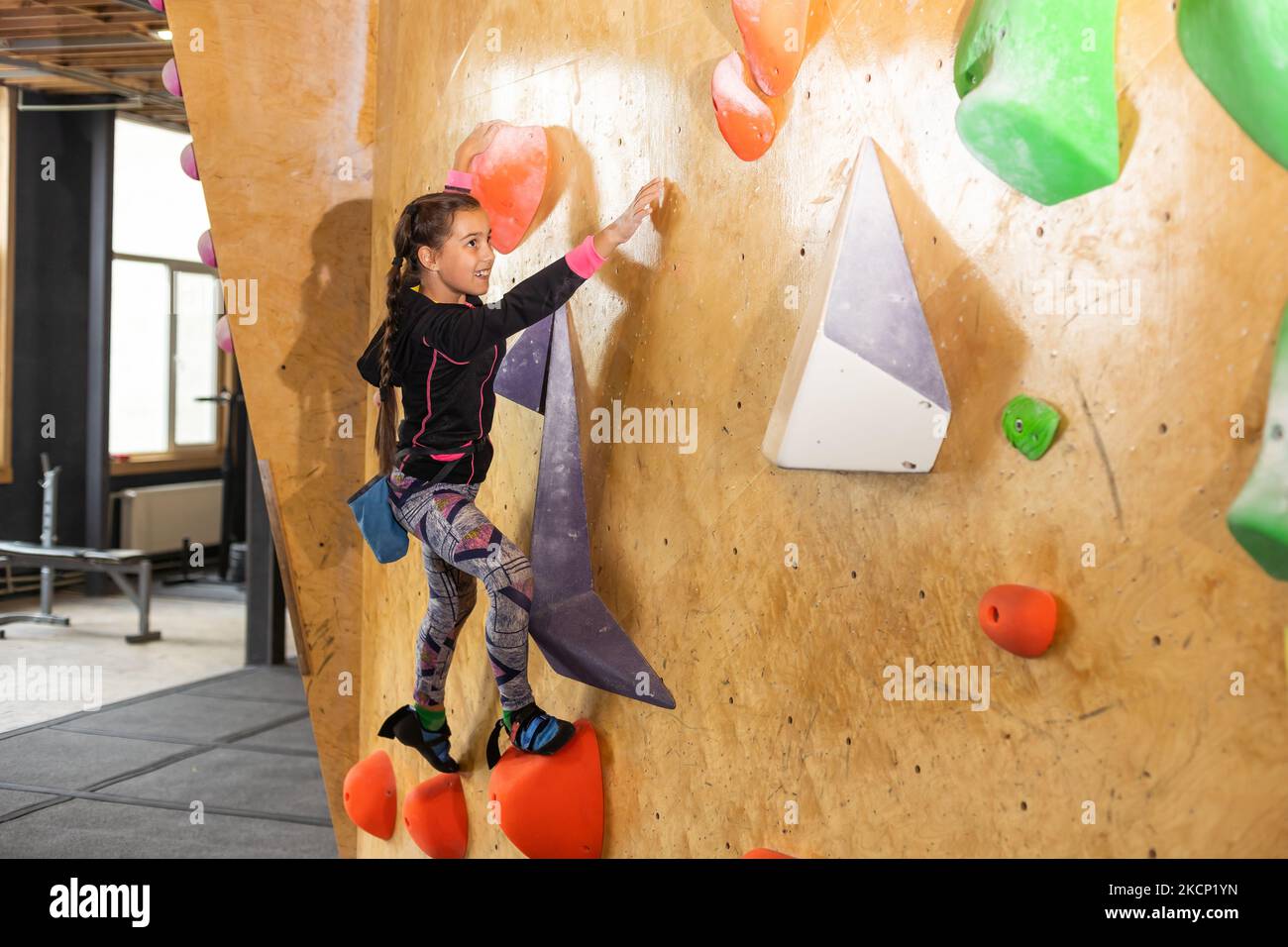 little girl climbing a rock wall indoor Stock Photo - Alamy