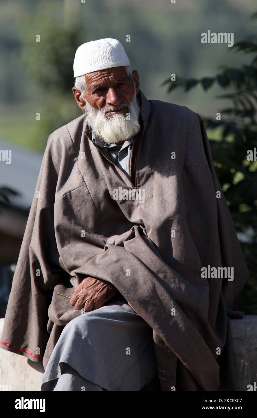 Muslim man wearing a kufi cap relaxes on a ledge in Wusan, Kashmir ...