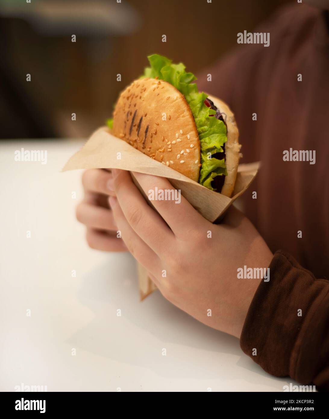 Juicy fresh burger with green lettuce in human hands. Cheeseburger in ...