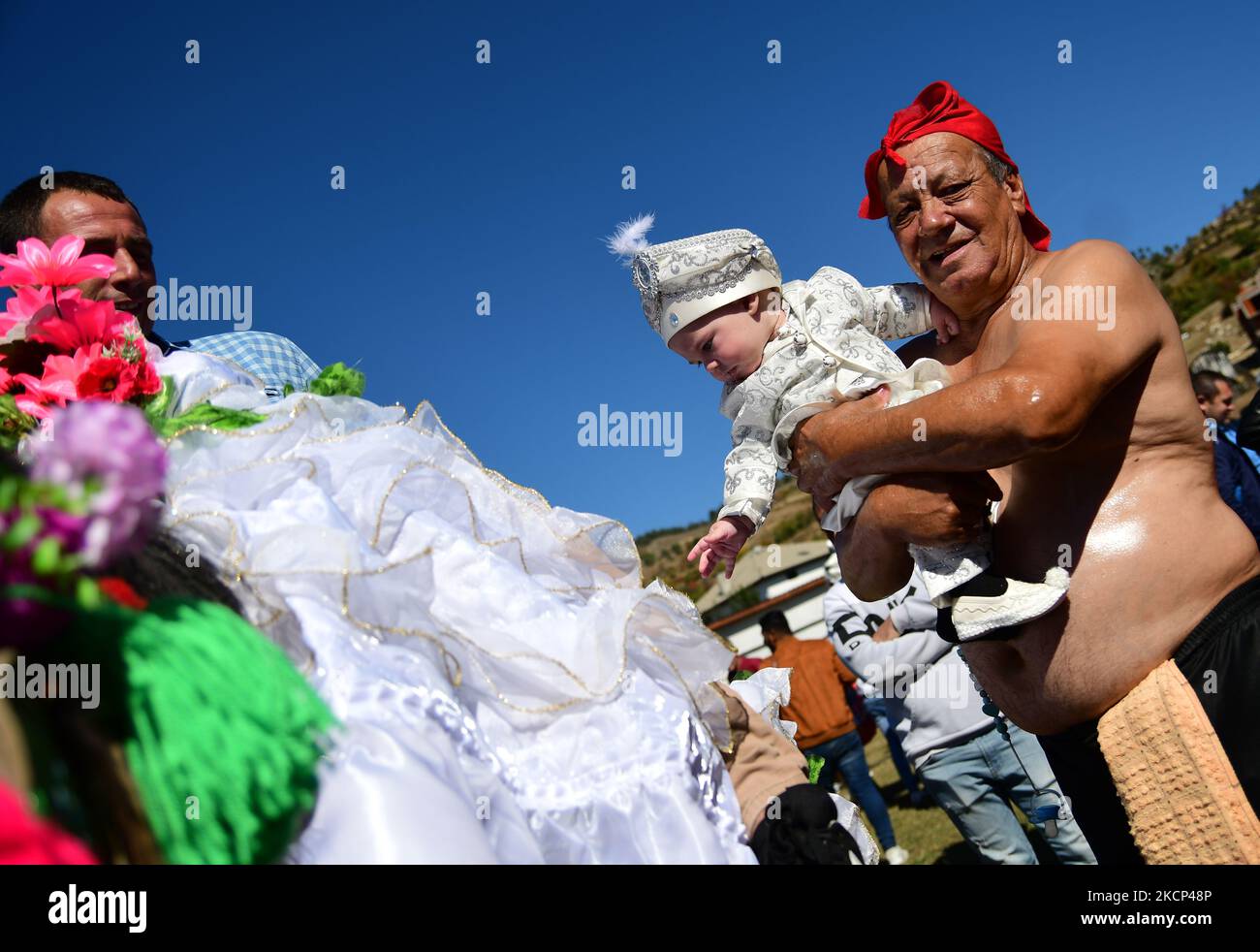 Man holds a baby before traditional circumcision ritual in Rhodope ...