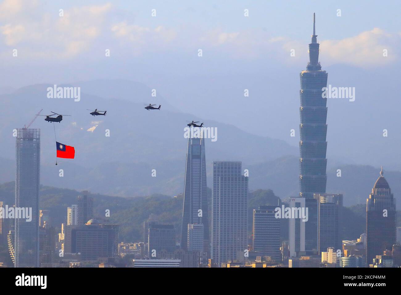 A military helicopter carrying a tremendous Taiwan flag flies over near ...