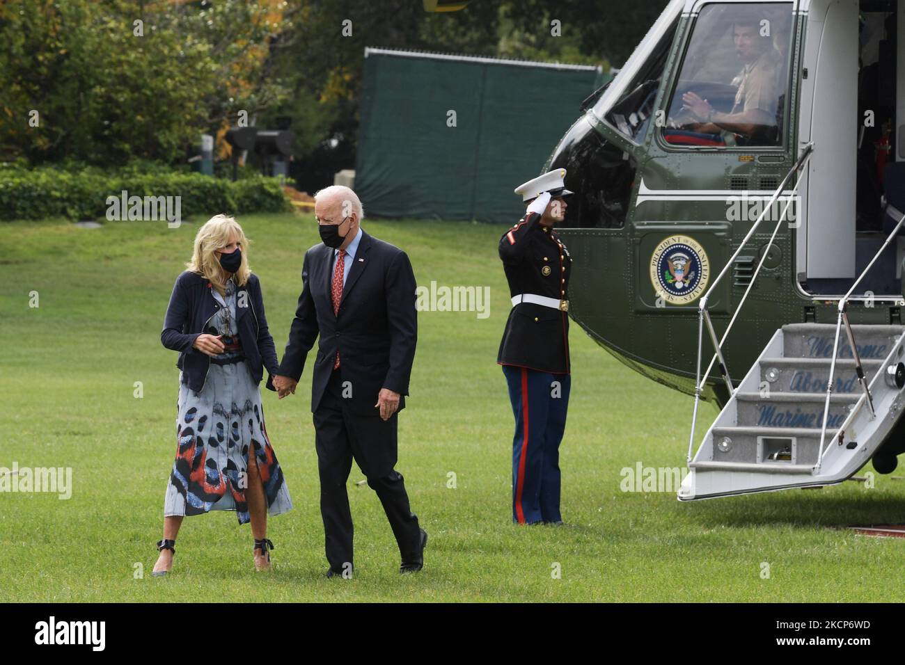 US President Joe Biden and First Lady Jill Biden walk through South ...