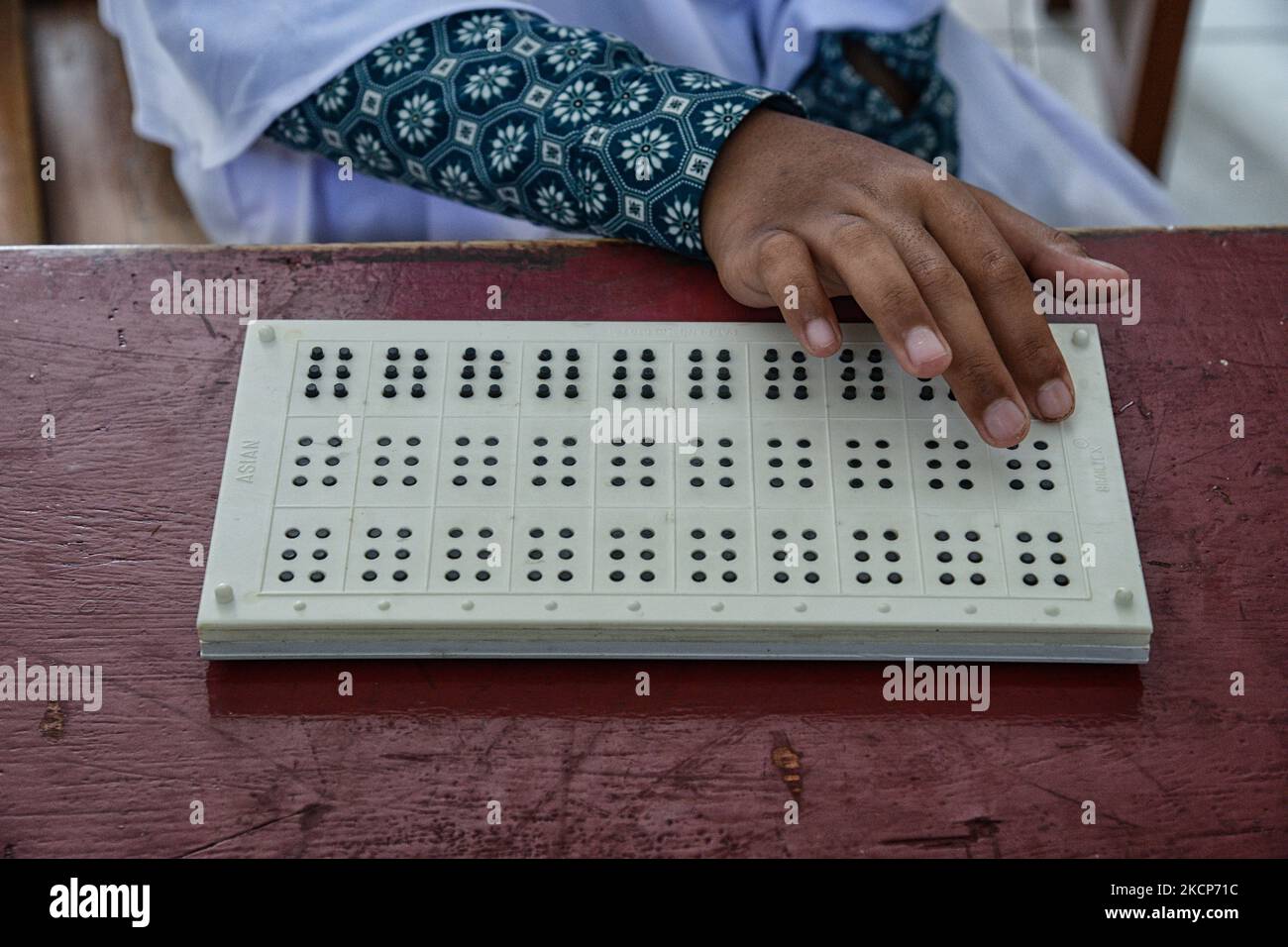 A visually impaired Indonesian student, uses the Braille system during ...