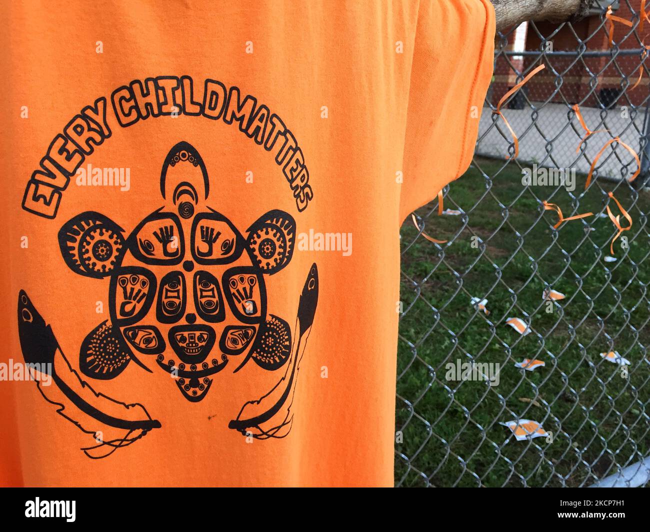 An orange shirt hangs by small notes with the names of children and the ...