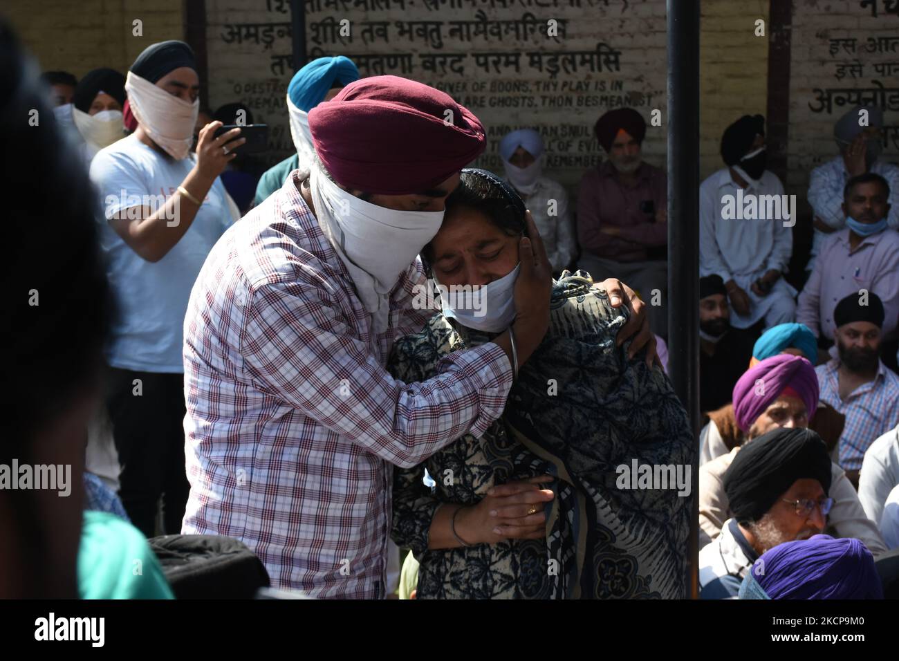 Sikh mourners wail around the dead body of the slain school principal ...