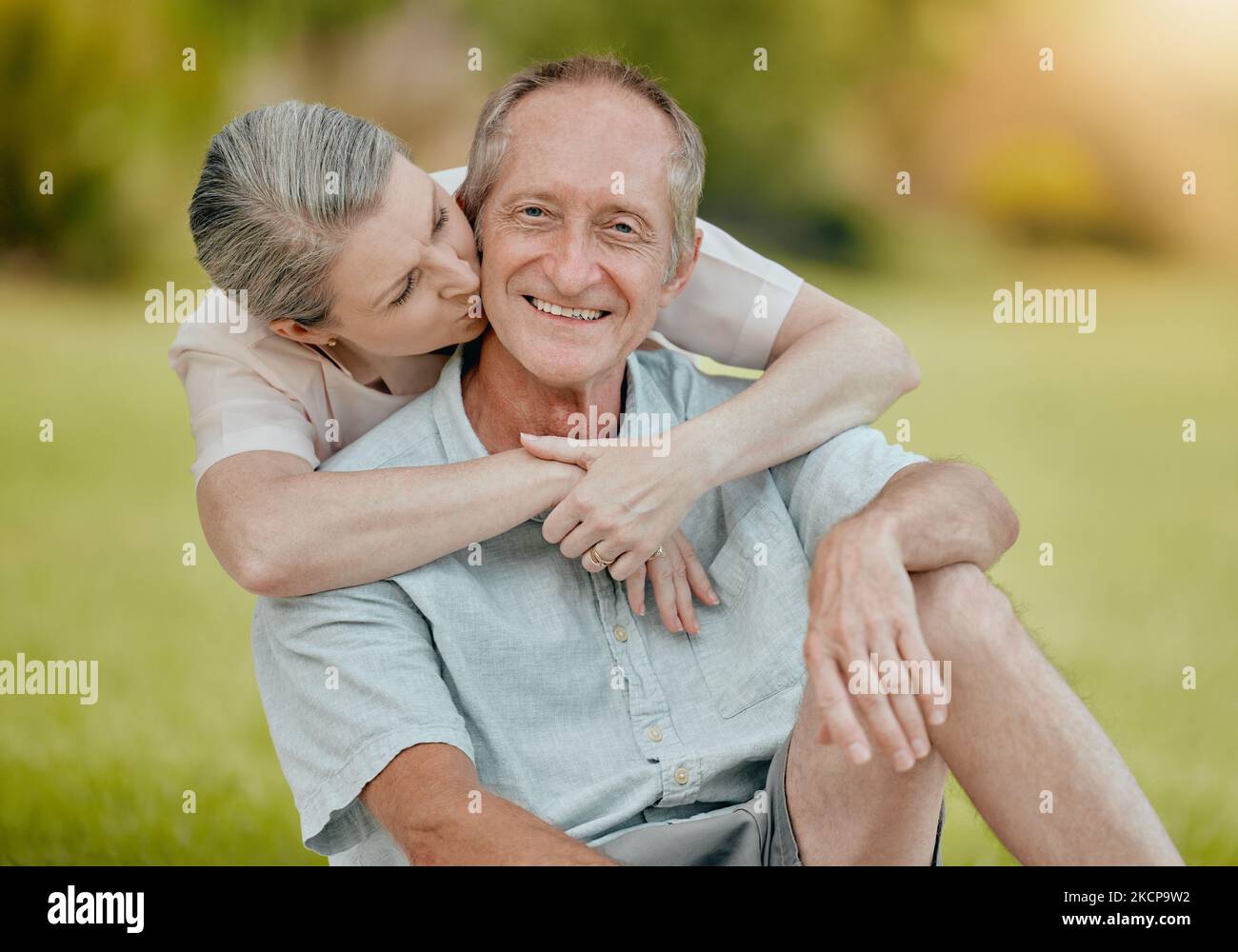 Senior couple, park and kiss for love, affection and care outside in a ...