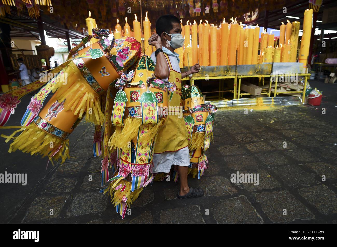 A temple worker holds decorations at Joe Sue Kung Shrine Chinese temple ...