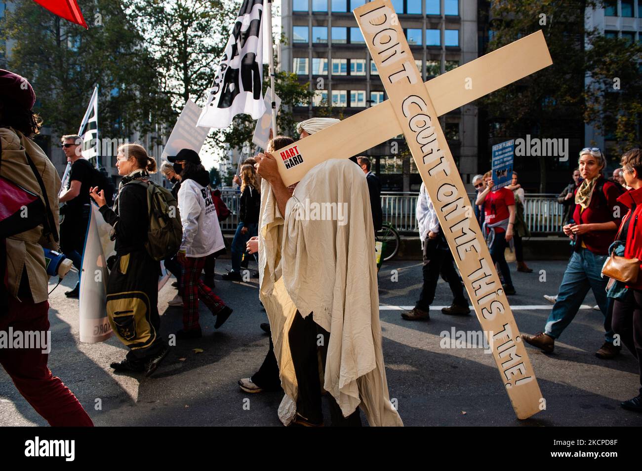 A man is carrying a wood cross, like Jesus with a message that says don ...