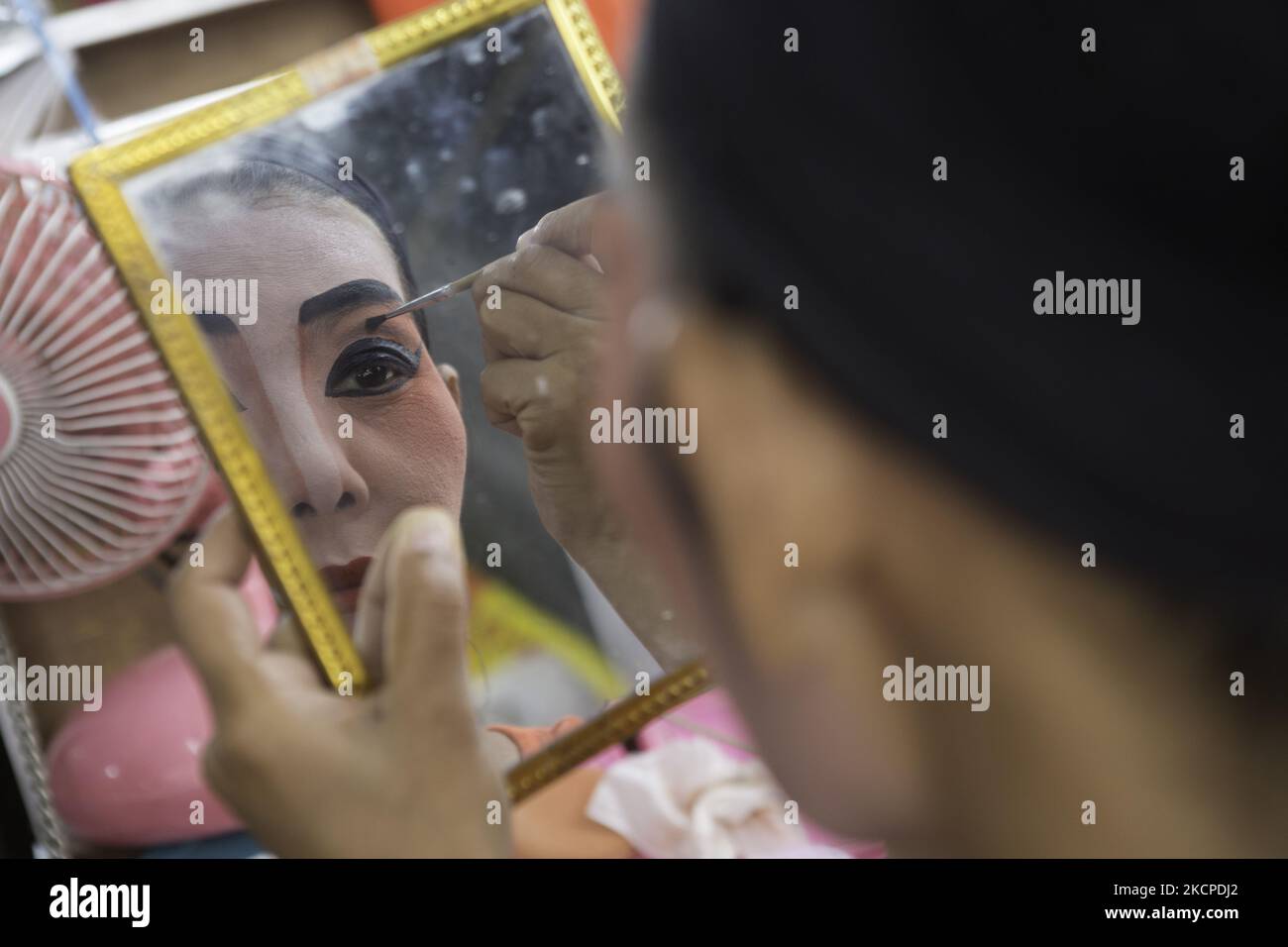Chinese opera performers putting on make-up before performing at the ...