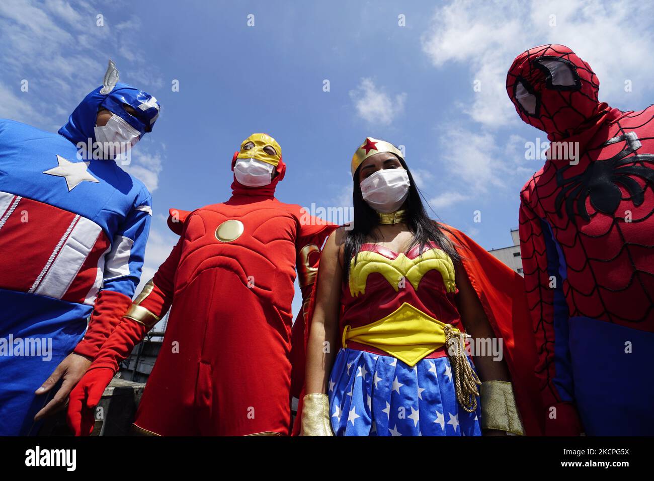 Window cleaners wearing superhero costumes greet a patient at a ...