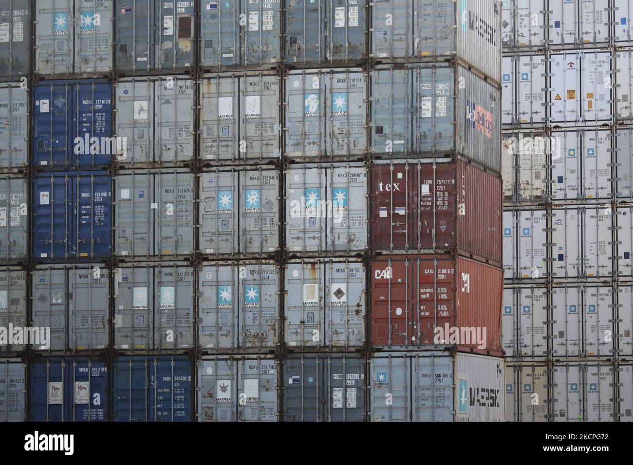 Shipping containers are piled several stories high and as far as the ...