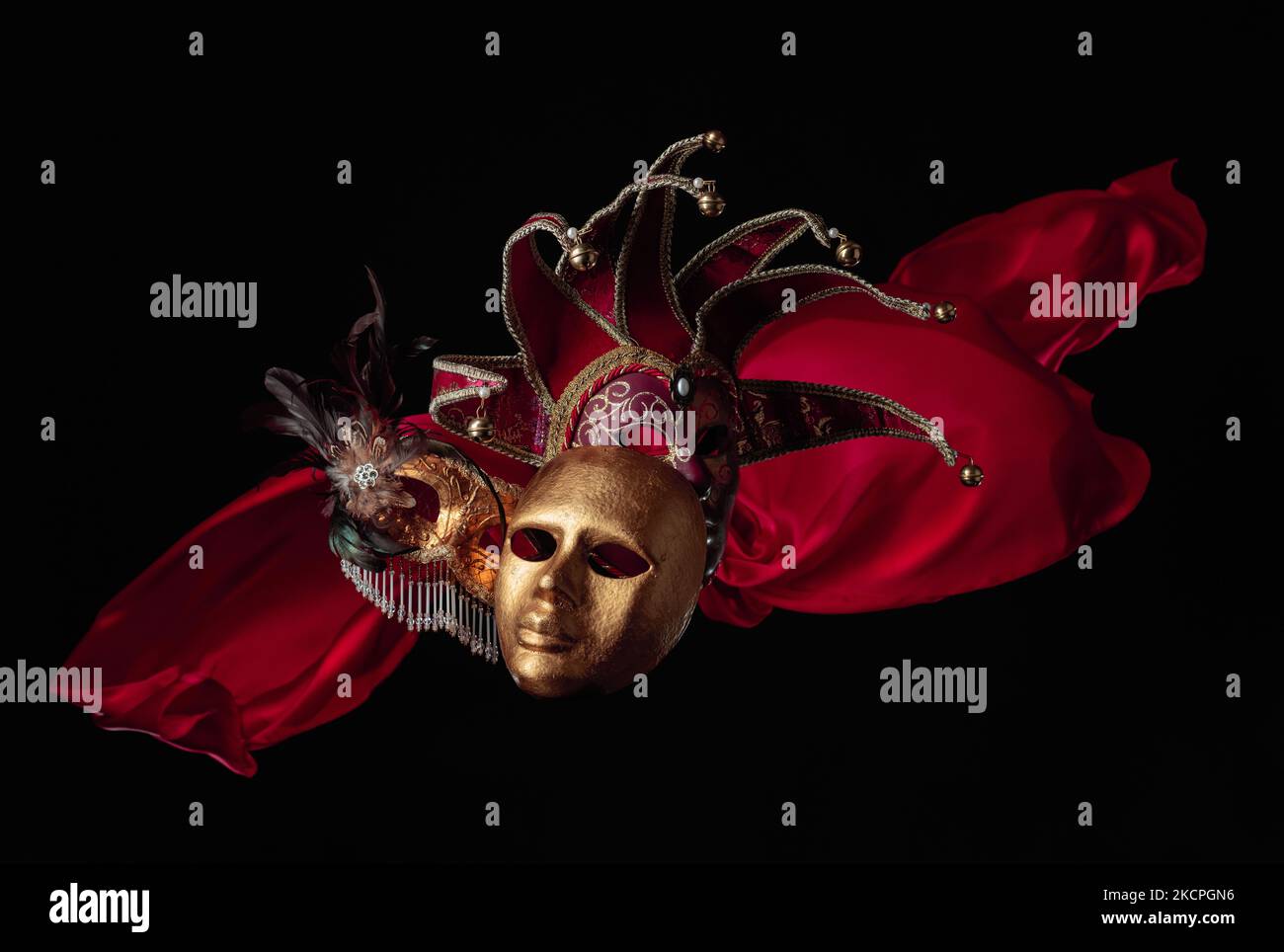 Old carnival masks on a black background with flutters red cloth. Copy ...